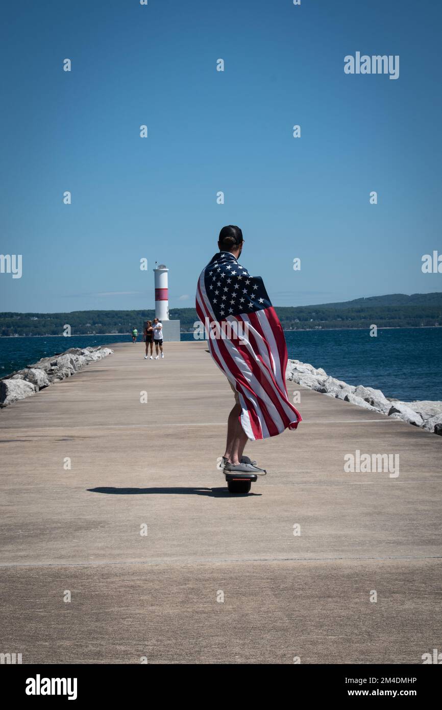 A closeup view of a man skateboarding with an American flag on his ...