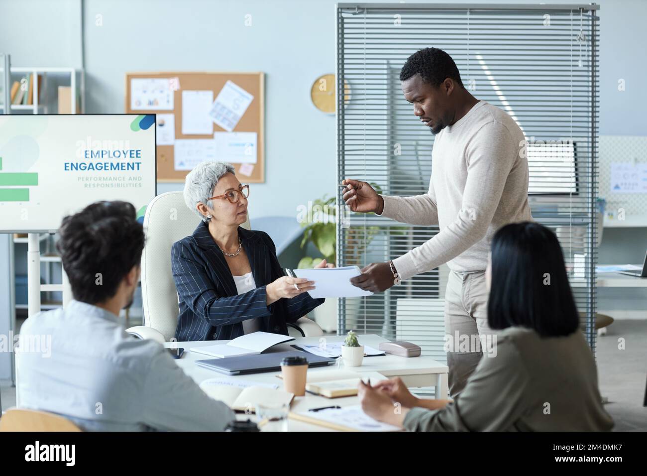 Side view portrait of black man giving presentation to female manager ...