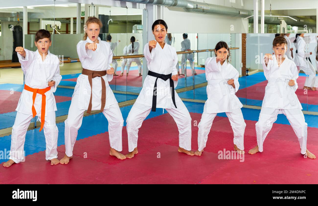 Female trainer is training teenagers in karate class Stock Photo - Alamy