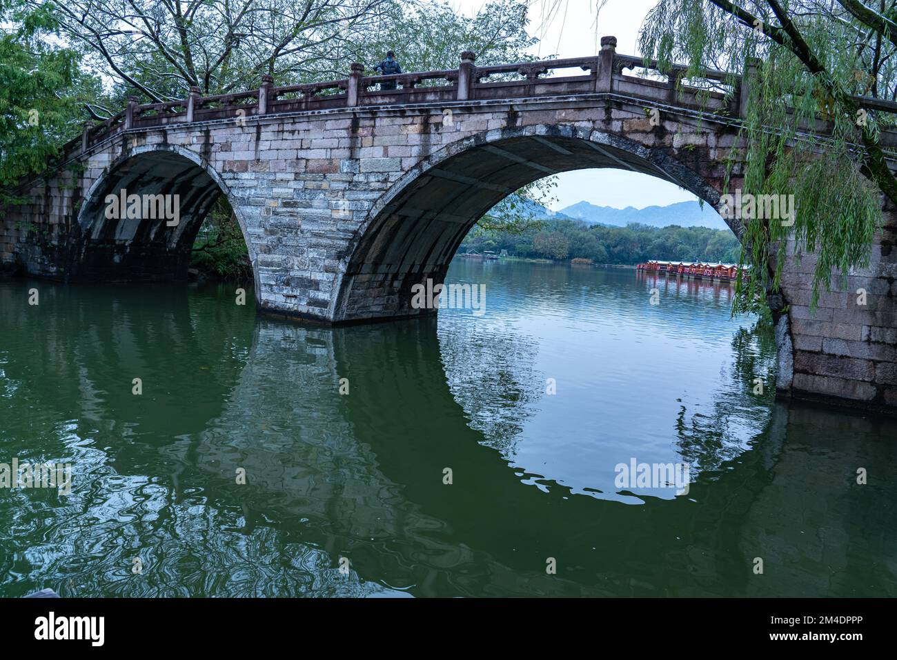 A scenic scenery with a reflection of a semi circular stone bridge ...