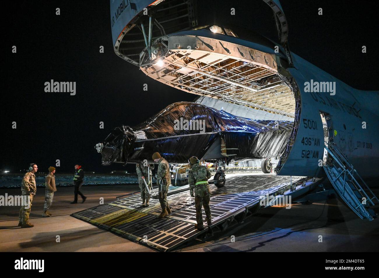 Airmen pull the fuselage of an F-22 Raptor from inside a C-5M Galaxy ...