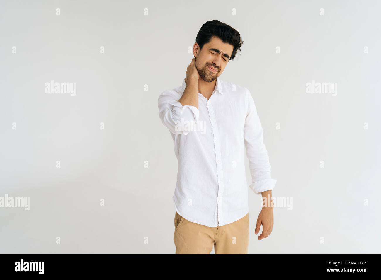 Studio portrait of unhealthy young man feeling physical discomfort ...