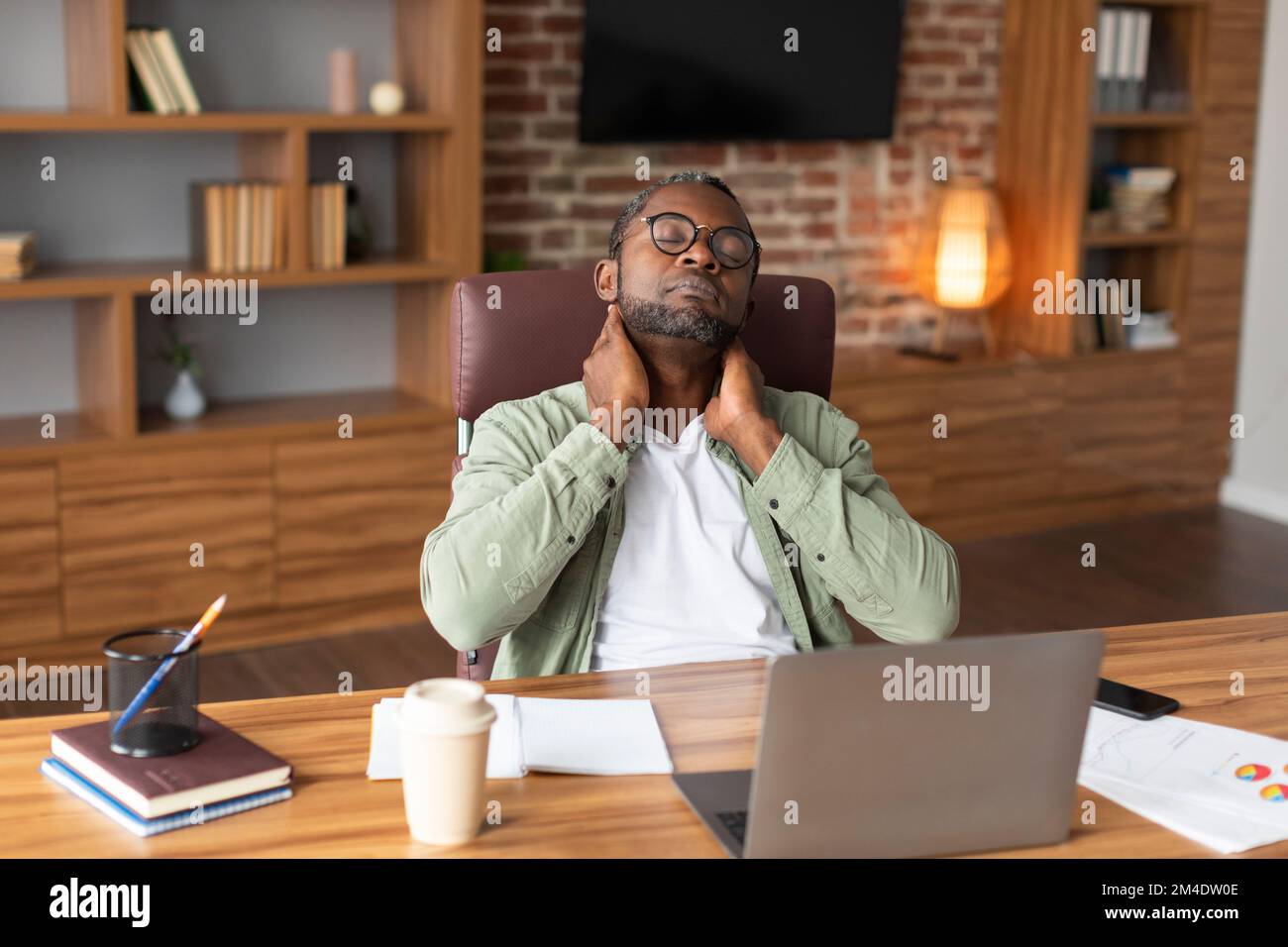 Tired adult black businessman in glasses suffering from neck pain ...
