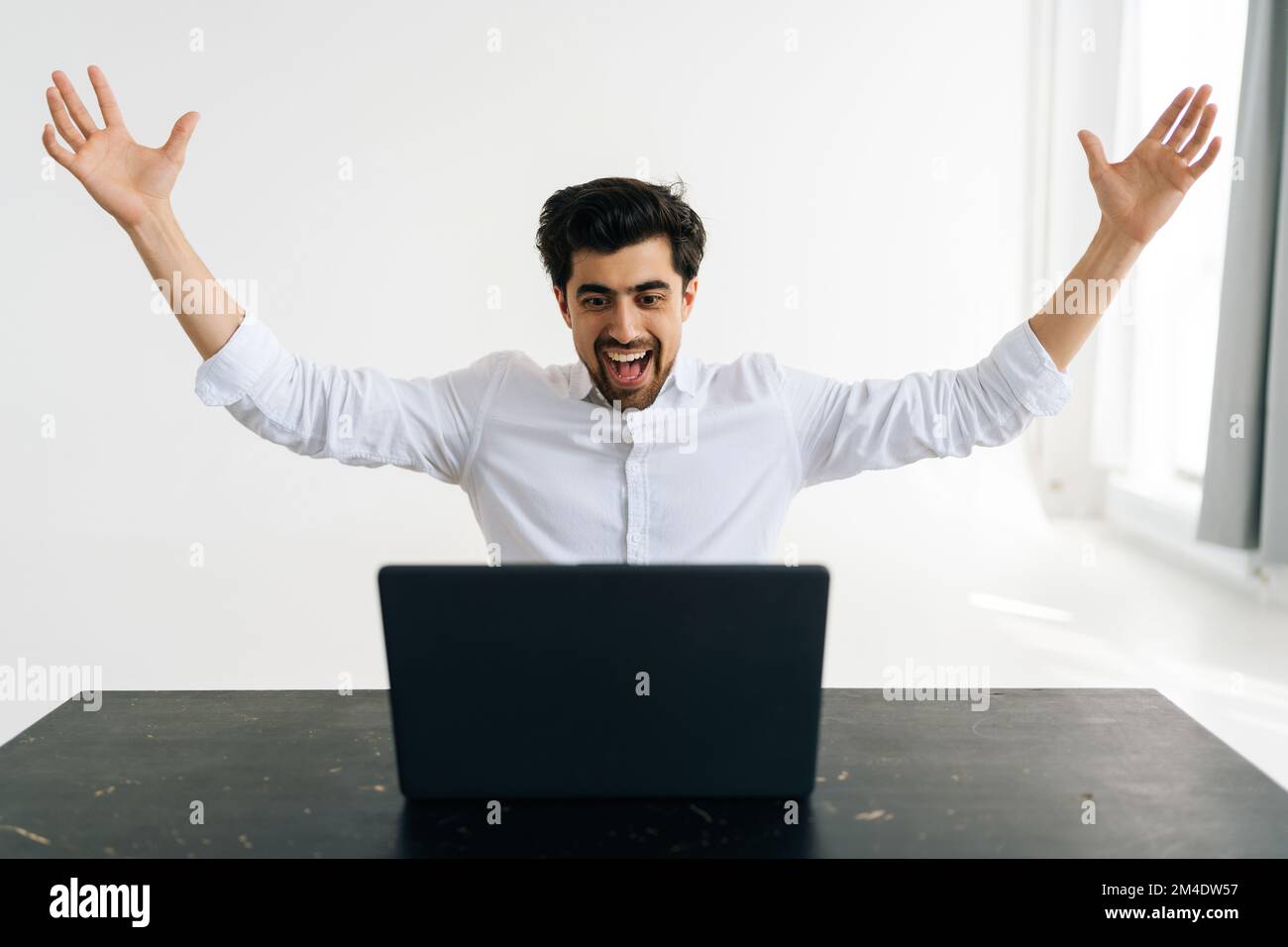 Studio portrait of cheerful excited male office worker screaming eureka ...