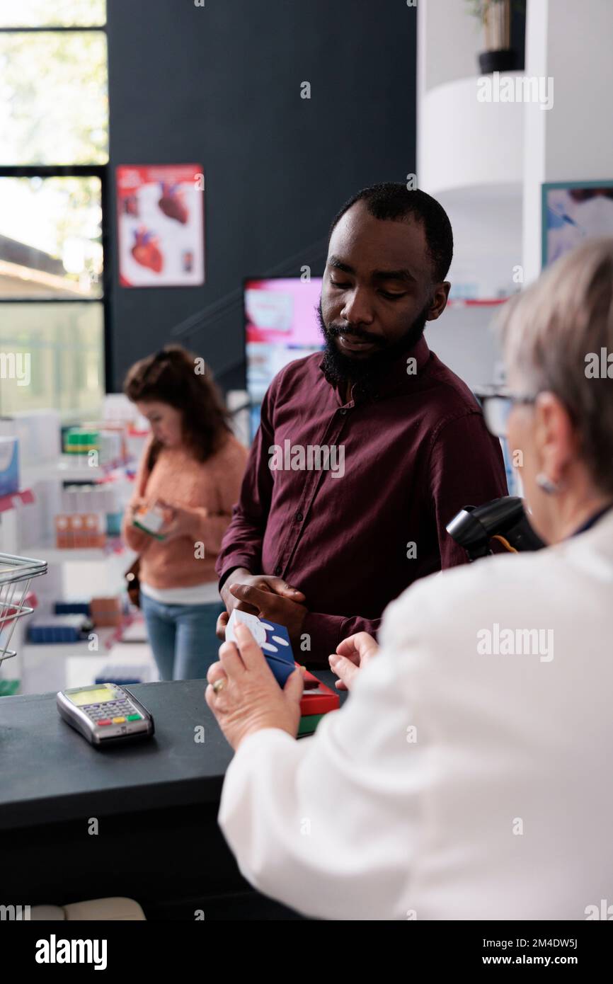 Pharmacy customer asking pharmacist for help with medication ...