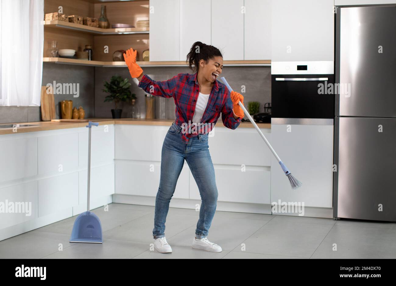 Happy millennial african african lady superstar in rubber gloves sings ...