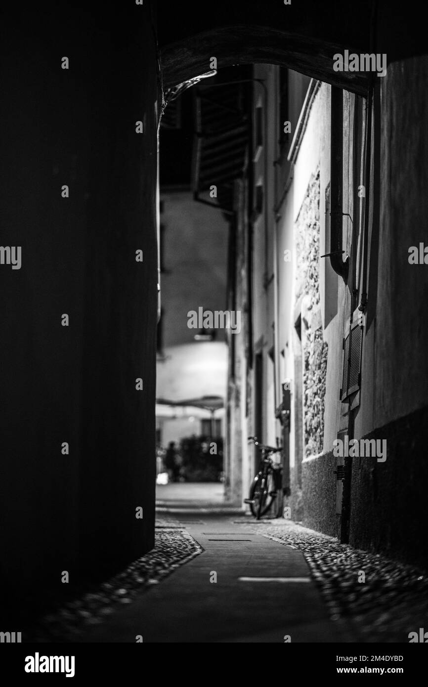A vertical grayscale shot of a narrow street Stock Photo - Alamy
