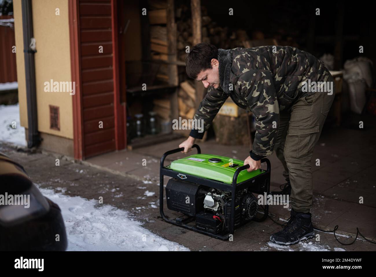 Man wear in military jacket with gasoline portable mobile backup ...