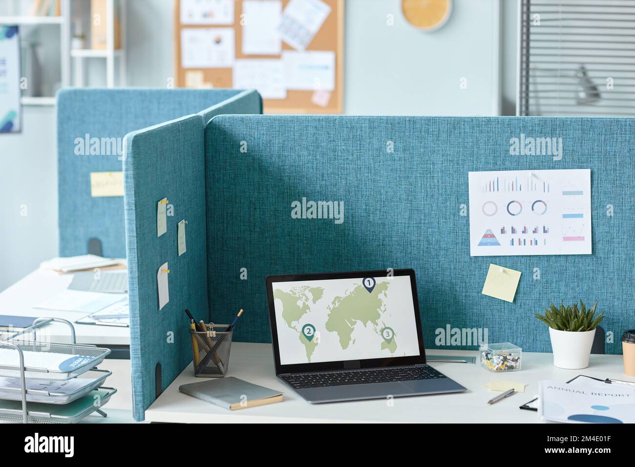 Background image of office cubicle with laptop on desk and world map ...