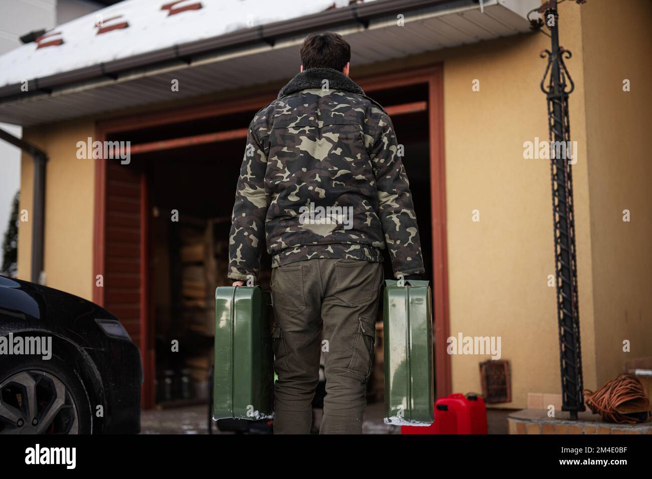 Man wear in military jacket with gasoline portable mobile backup ...