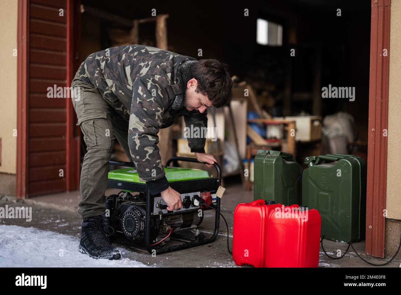 Man wear in military jacket with gasoline portable mobile backup ...