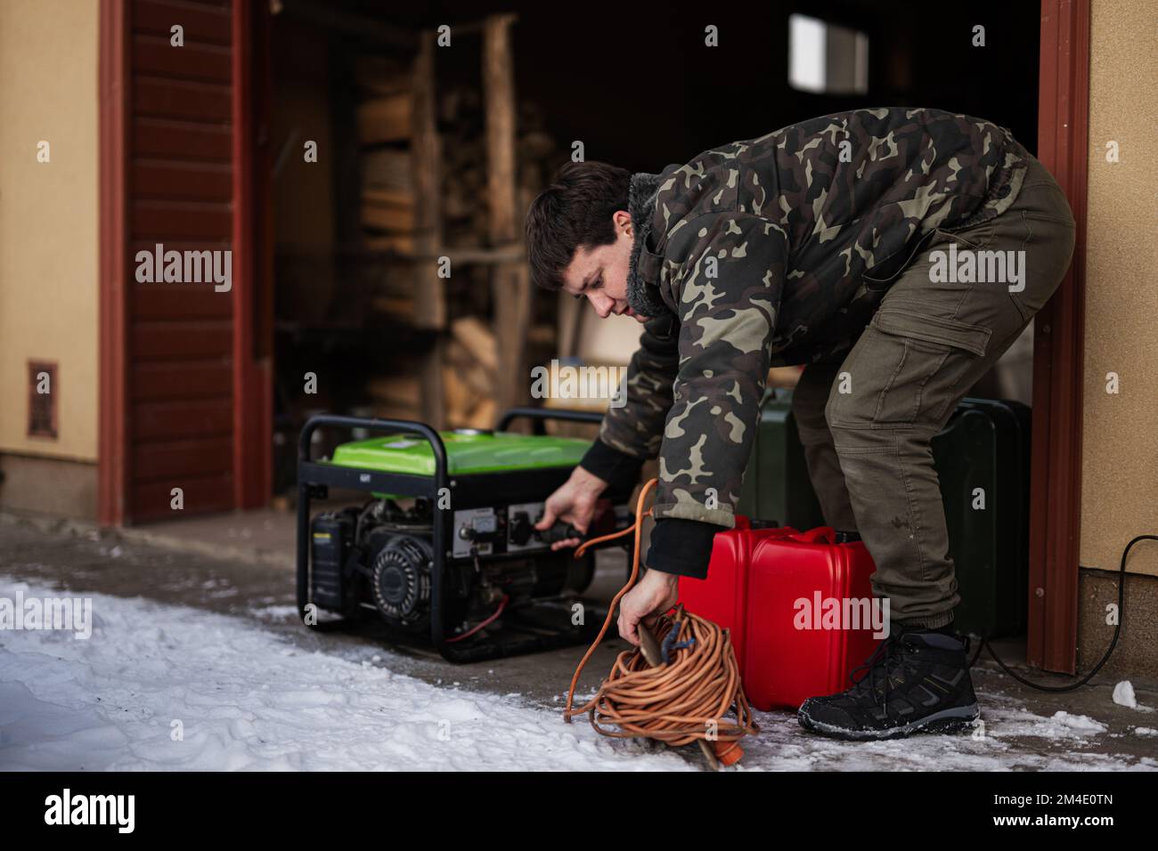 Man wear in military jacket with gasoline portable mobile backup ...