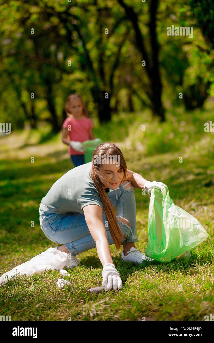 Cute family working in a park gathering garbage Stock Photo - Alamy