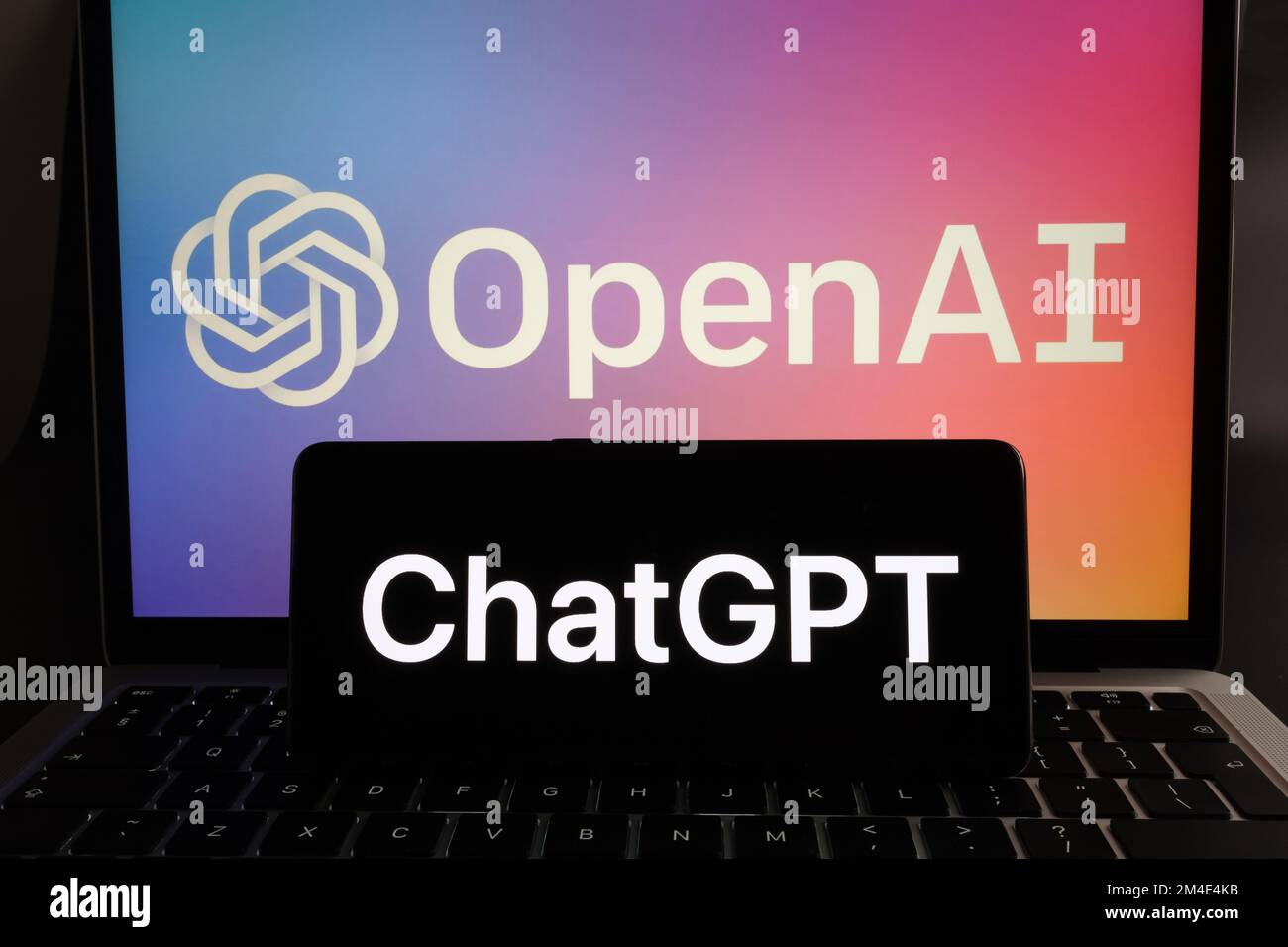 ChatGPT logo seen on smartphone and laptop display with blurred OpenAI company logotype. AI ...