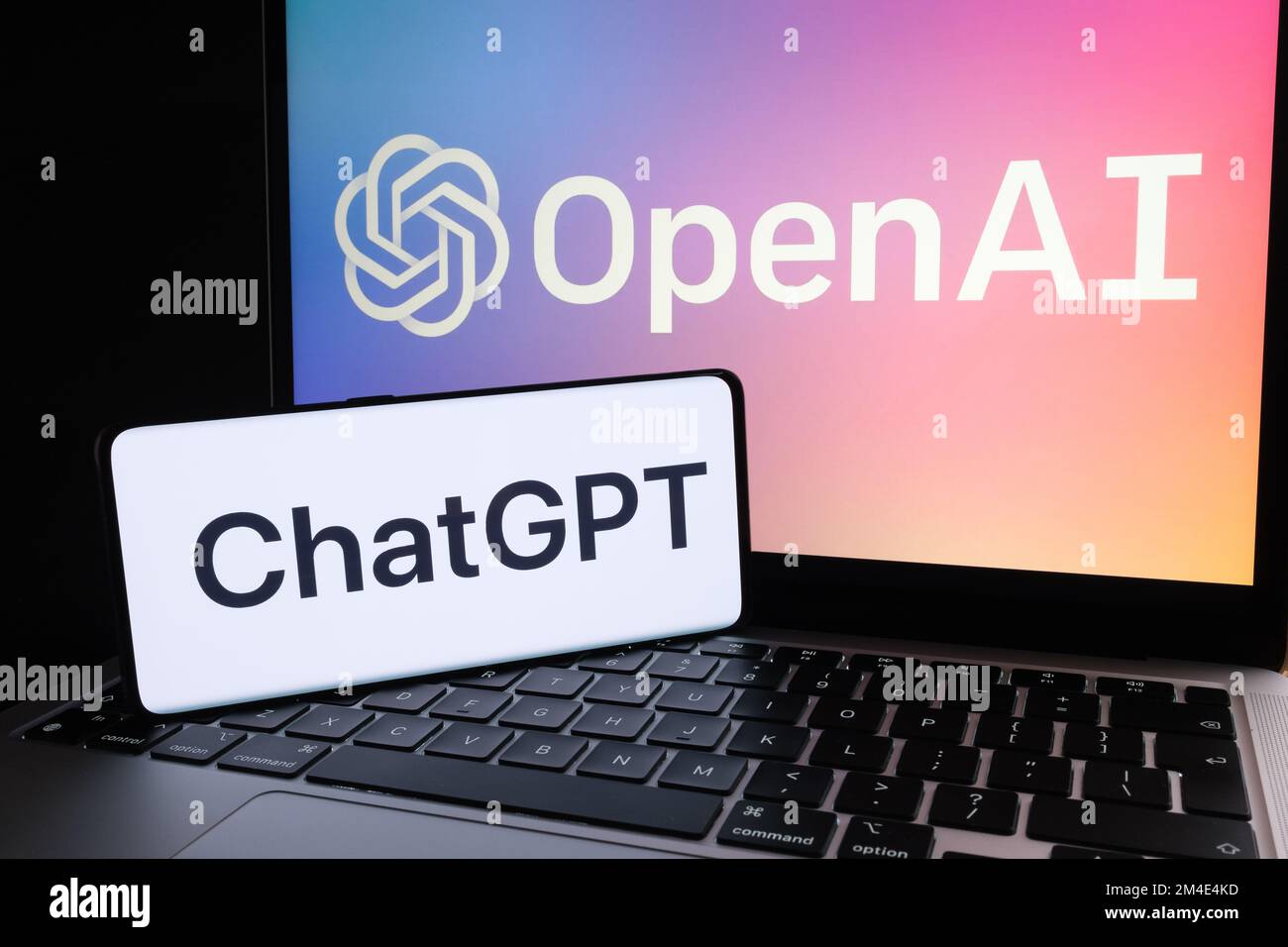 ChatGPT logo seen on smartphone and laptop display with blurred OpenAI company logotype. AI ...