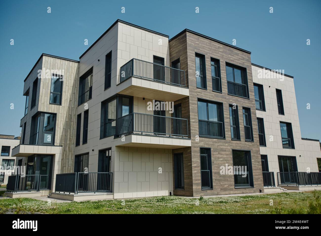 Wide angle shot of modern apartment building in housing complex lit by ...