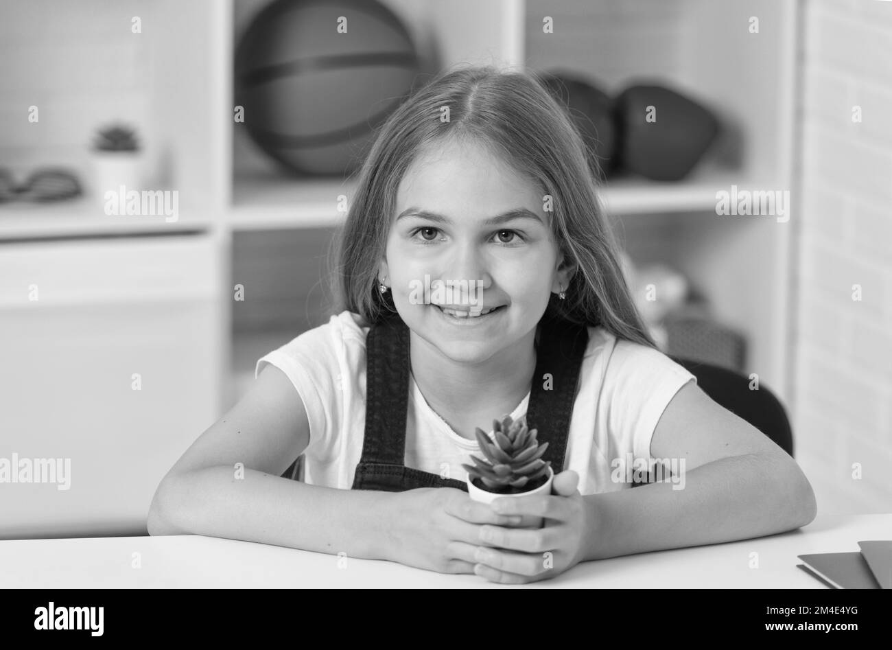 happy child holding plant in pot at school classroom on lesson ...