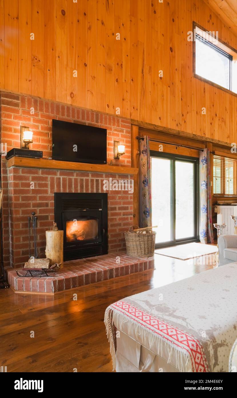 Red brick wood burning fireplace in living room inside log home Stock ...