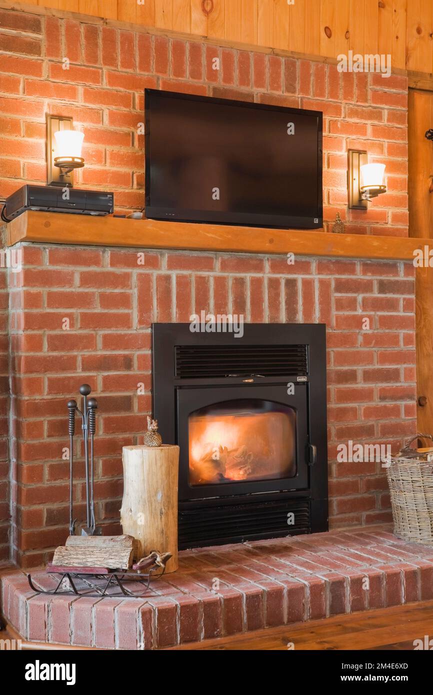 Red brick wood burning fireplace in living room inside log home Stock ...