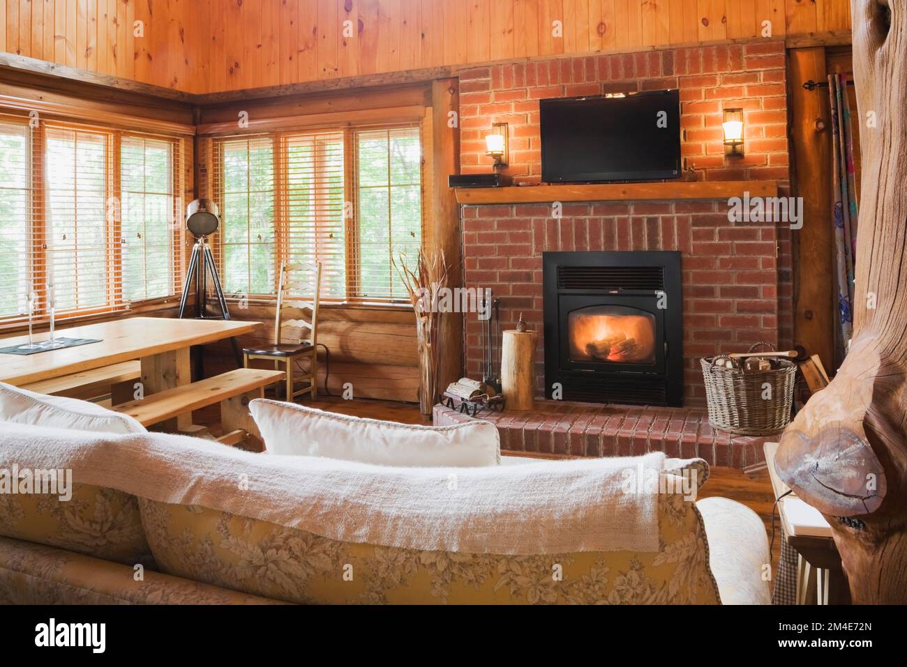 Red brick wood burning fireplace in living room inside log home Stock ...
