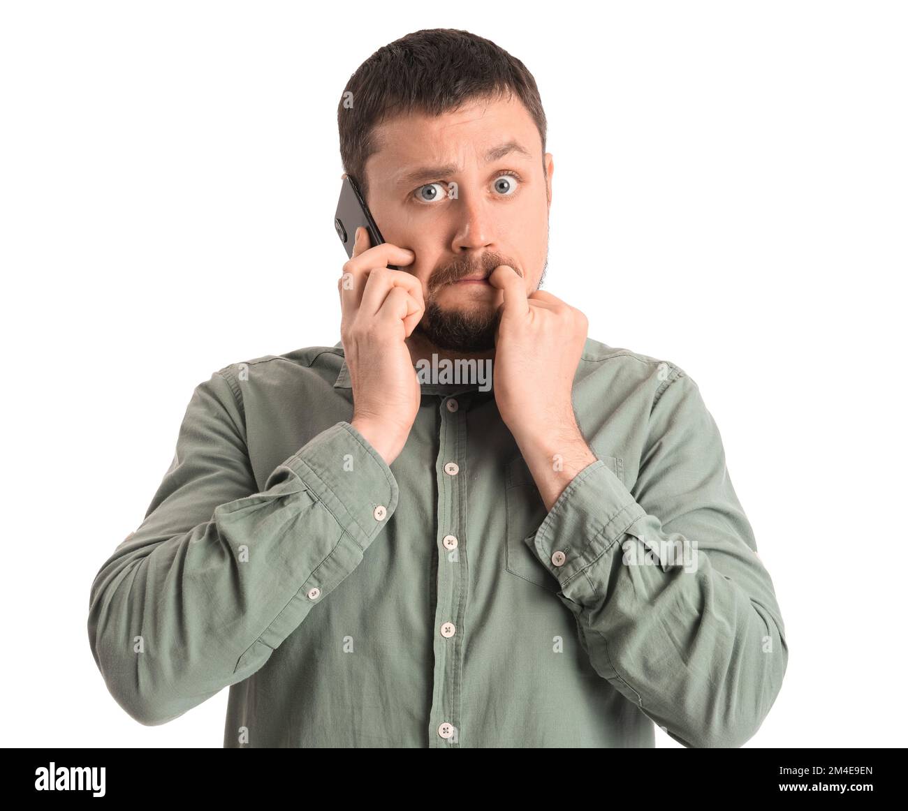 Handsome man biting nails and talking by mobile phone on white ...