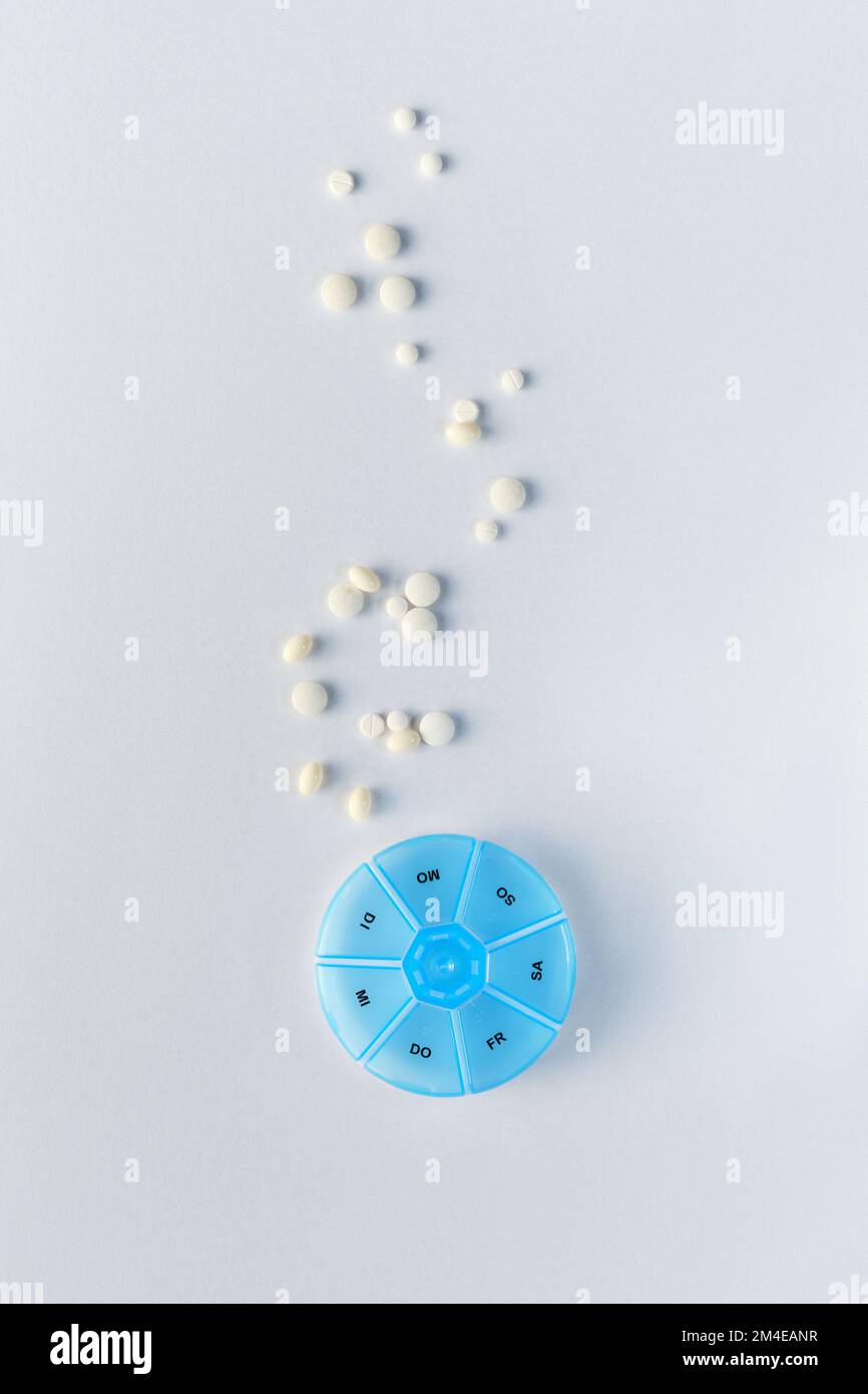 Tablet, pill dispenser and tablets. Flat lay, top view on off white ...