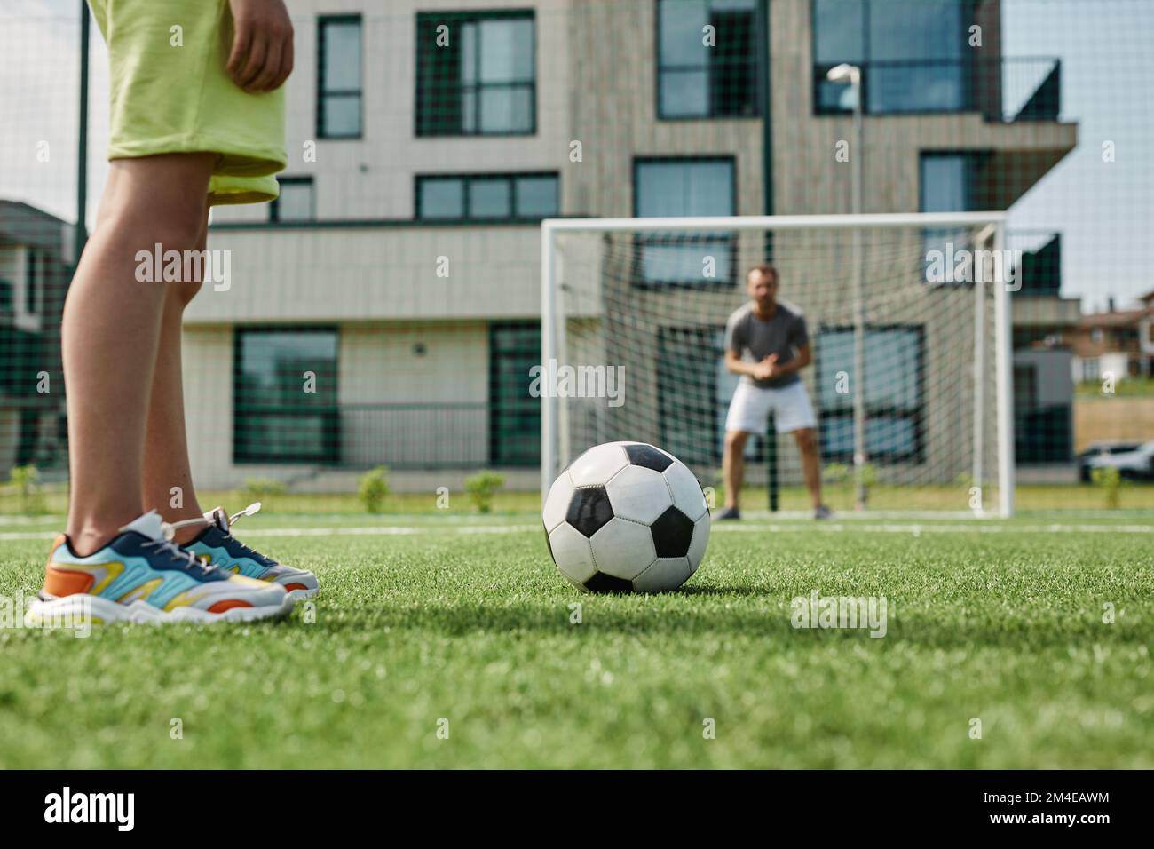Close up of unrecognizable boy playing football with father standing in ...
