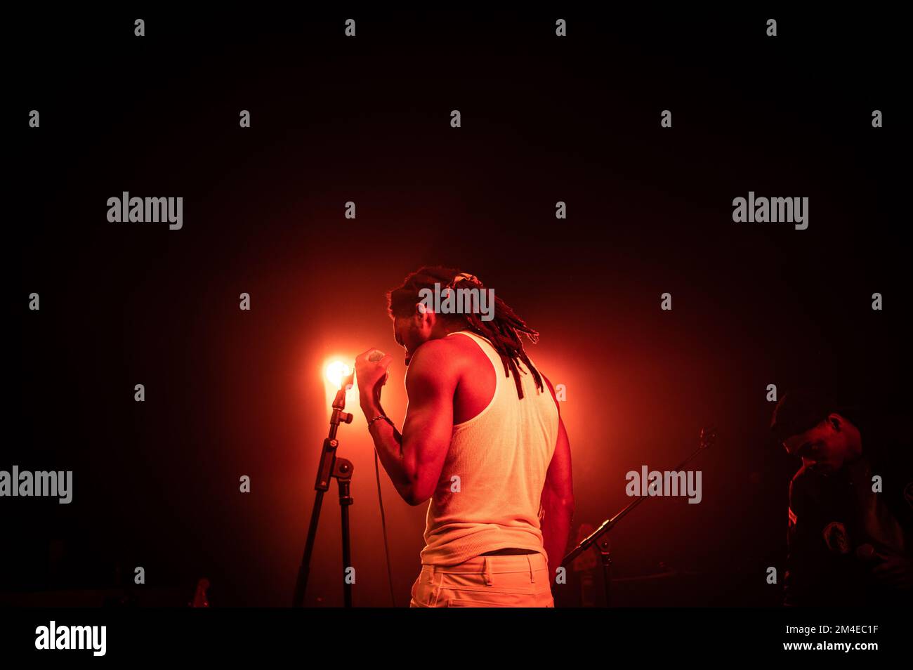 A rapper performing with a red background Stock Photo - Alamy
