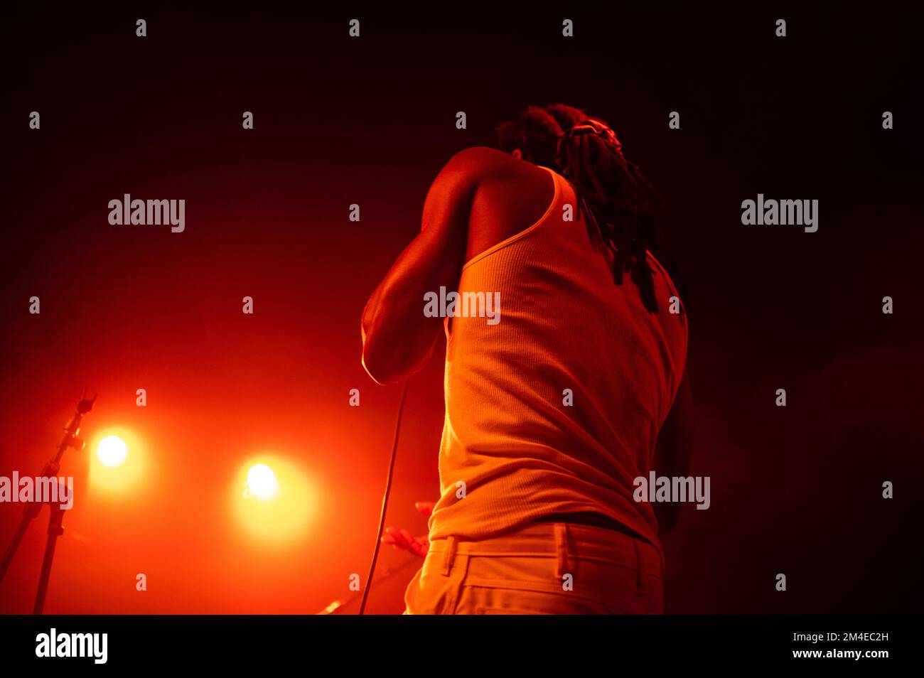 A rapper performing with a red background Stock Photo - Alamy