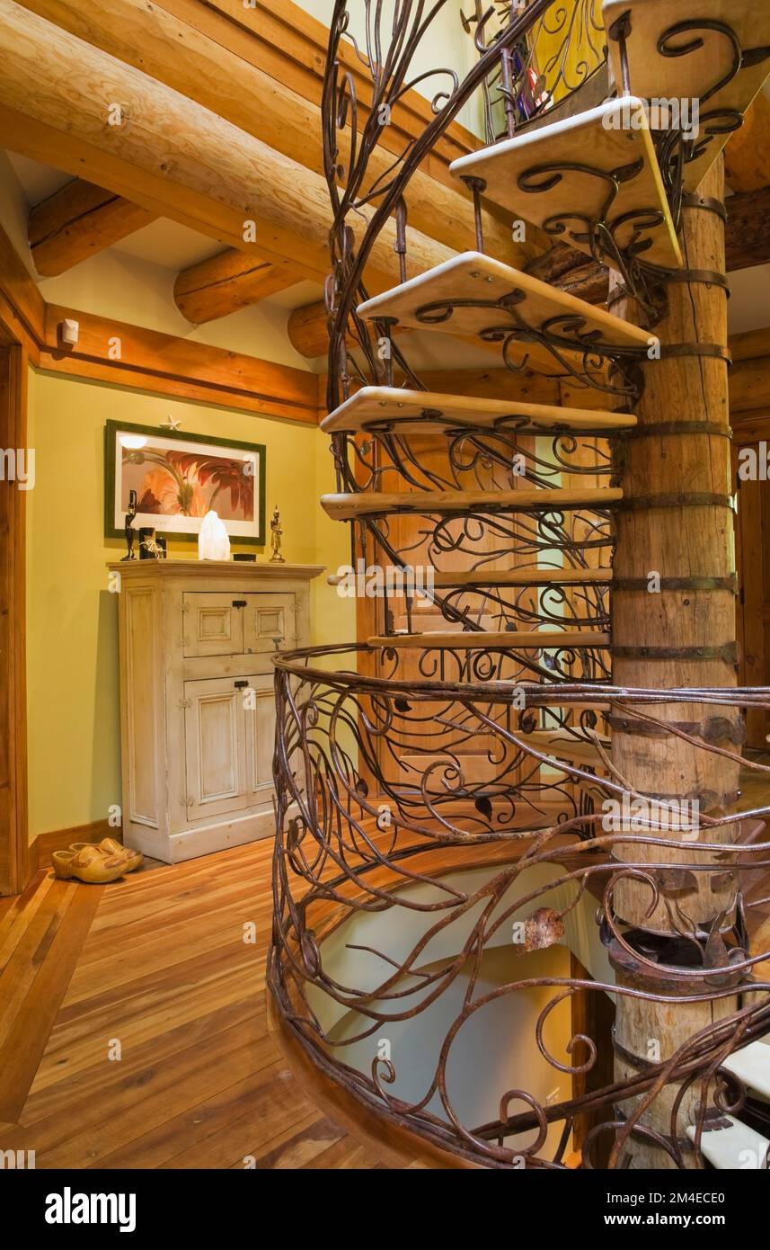 Spiral shaped wood and wrought iron staircase in living room inside ...