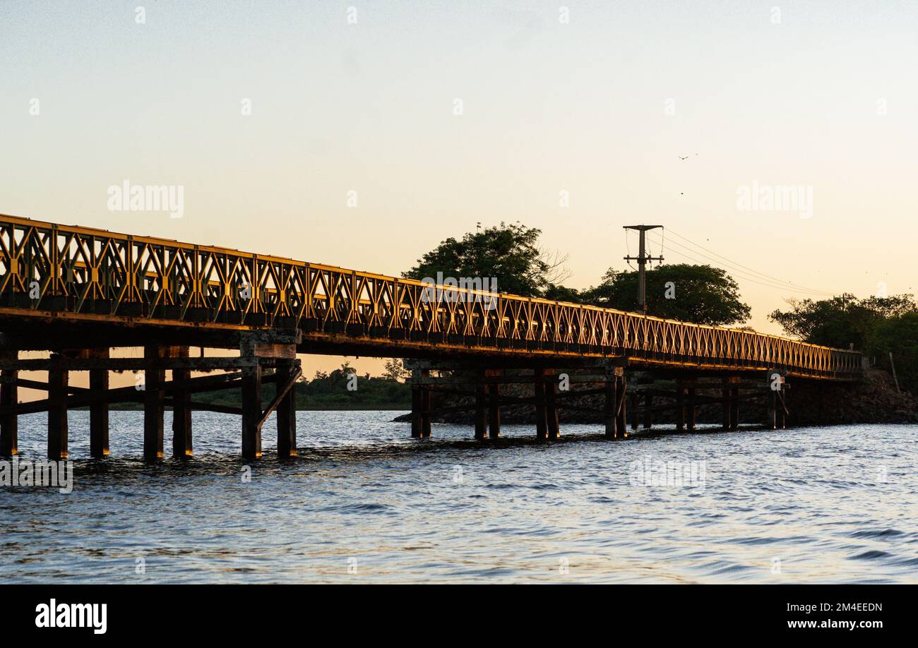 Beautiful landscape with an old iron and wooden bridge and a river ...