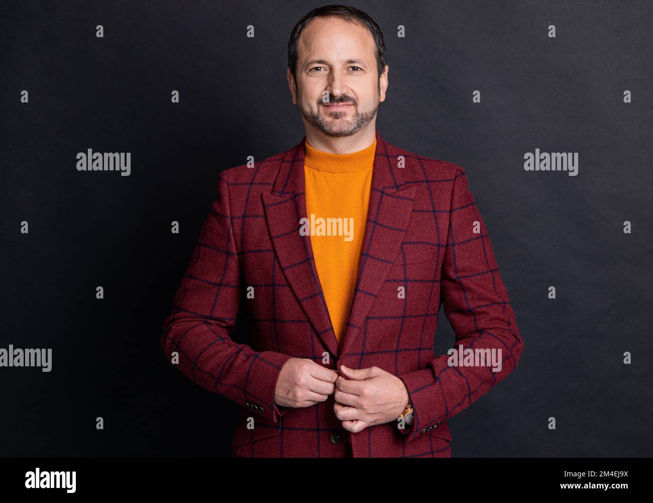 handsome mature man in stylish menswear isolated on black background ...