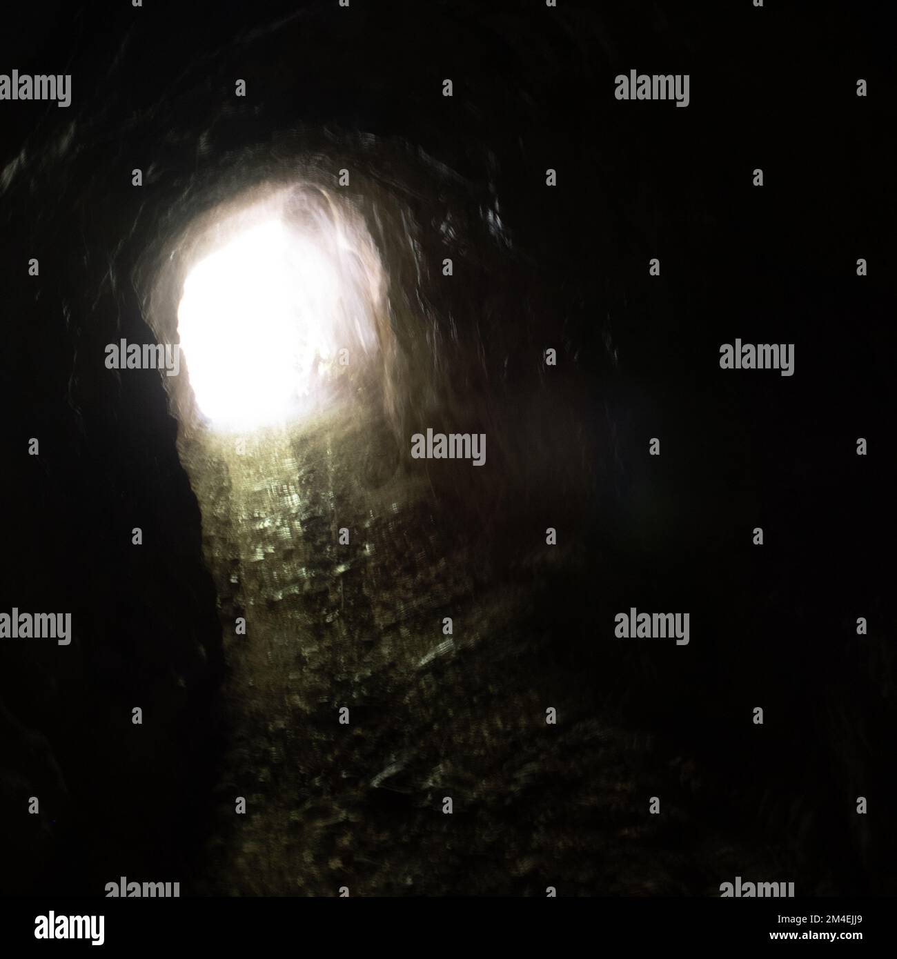 The bright light entering a cave Stock Photo - Alamy