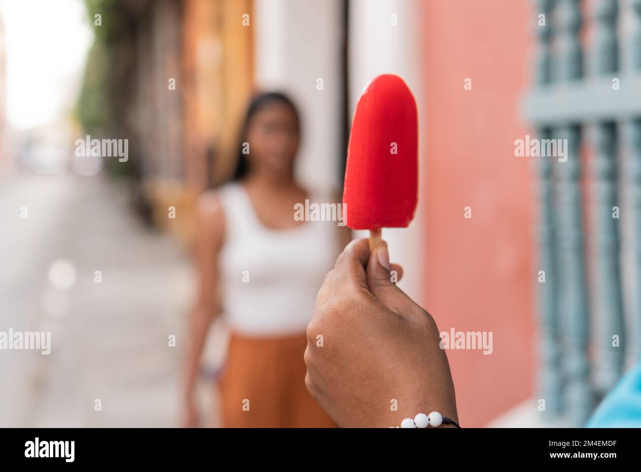 Anonymous woman eat popsicle while walking on the city's streets Stock ...