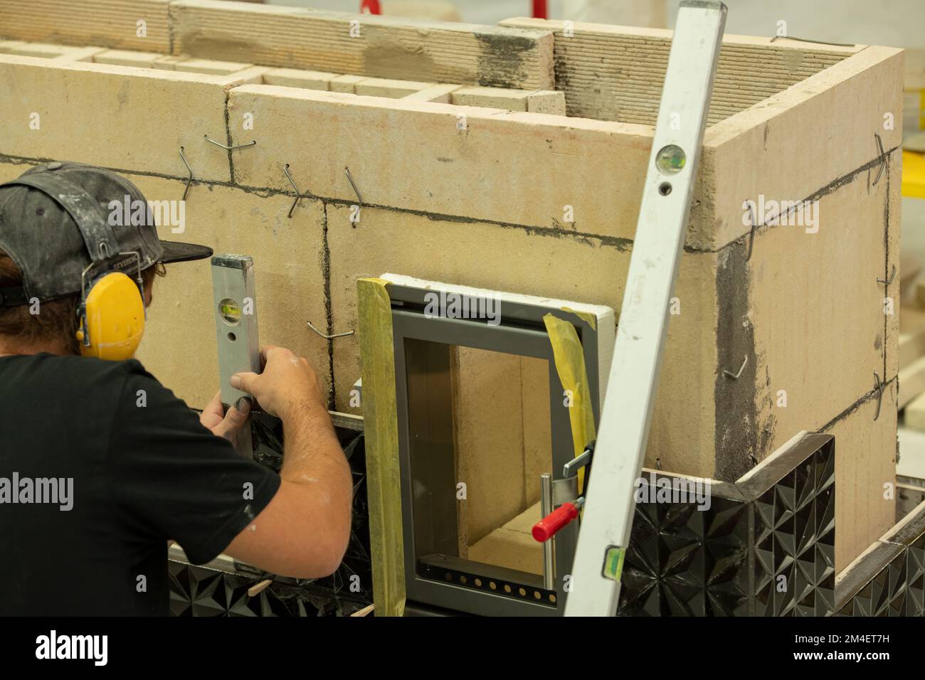 A closeup of a person taking measurements on a wall in a construction ...