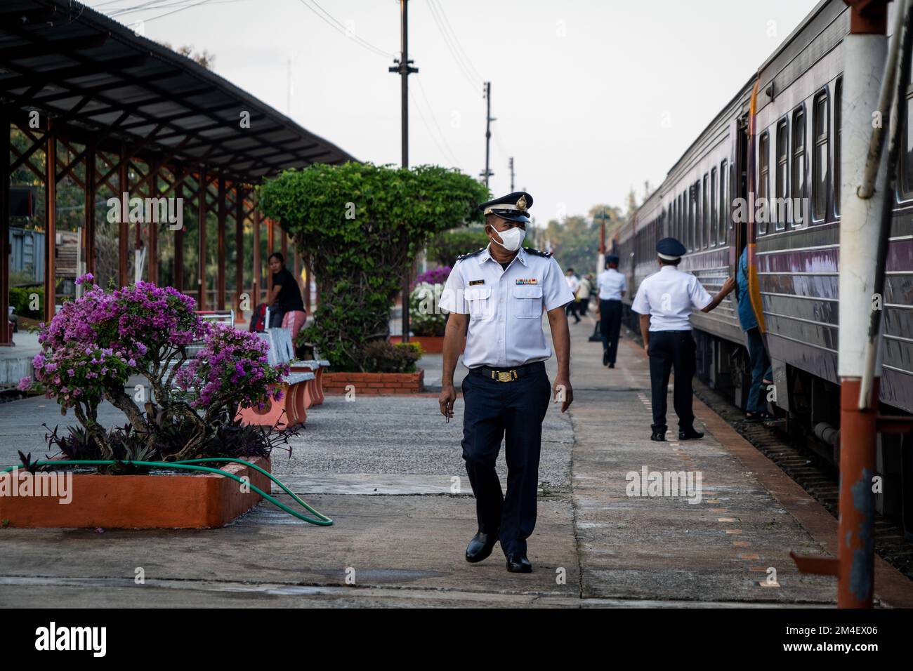 A train conductor inspects the cars and helps passengers board at ...