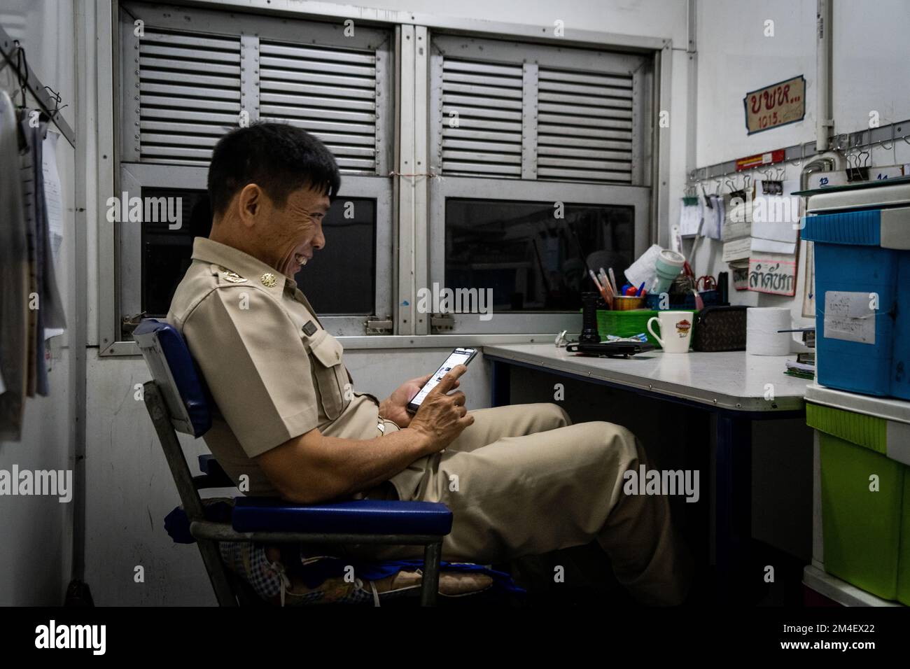 A train conductor checks passenger data while doing paperwork in the ...