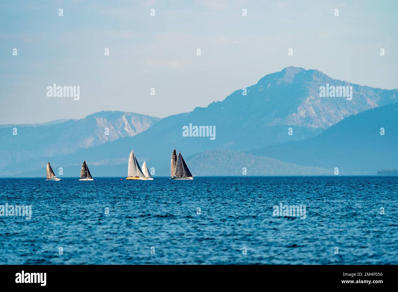 A beautiful view of sailboats sailing in the ocean and mountain in the ...