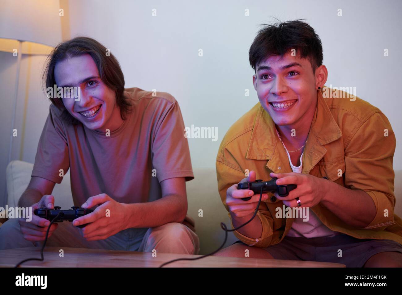 Excited cheerful best friends playing videogame at home Stock Photo - Alamy