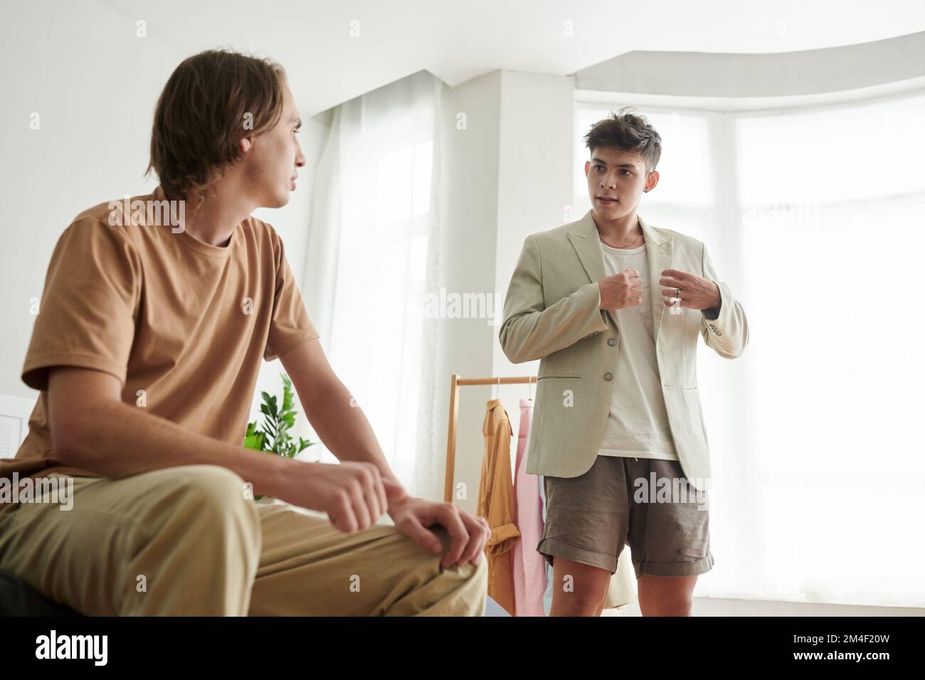 Young man asking friend what to wear for the first date Stock Photo - Alamy