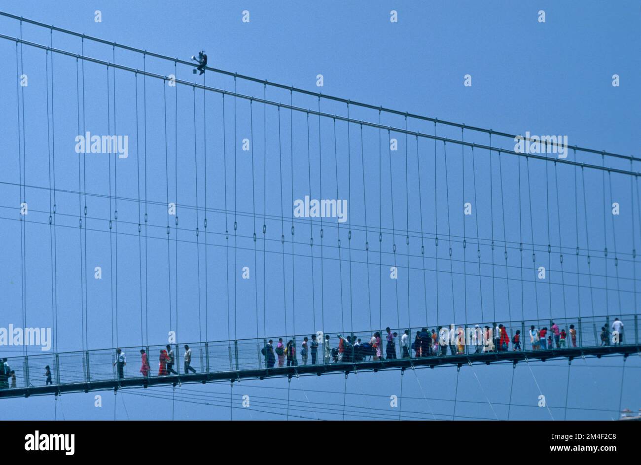 Ram Jhula, bridge over the River Ganges with lots of pilgrims getting ...