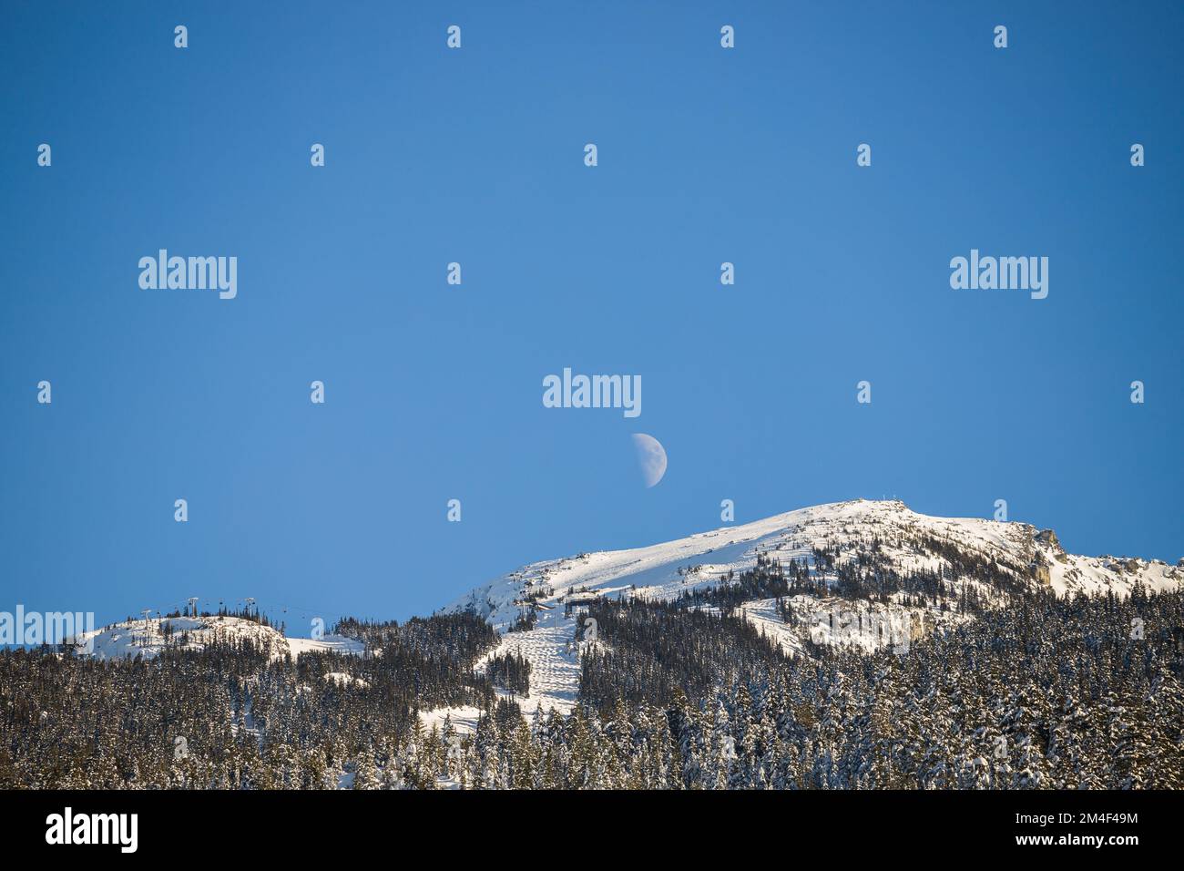 Blue sky, mountain and waxing white moon. Winter mountains landscape ...