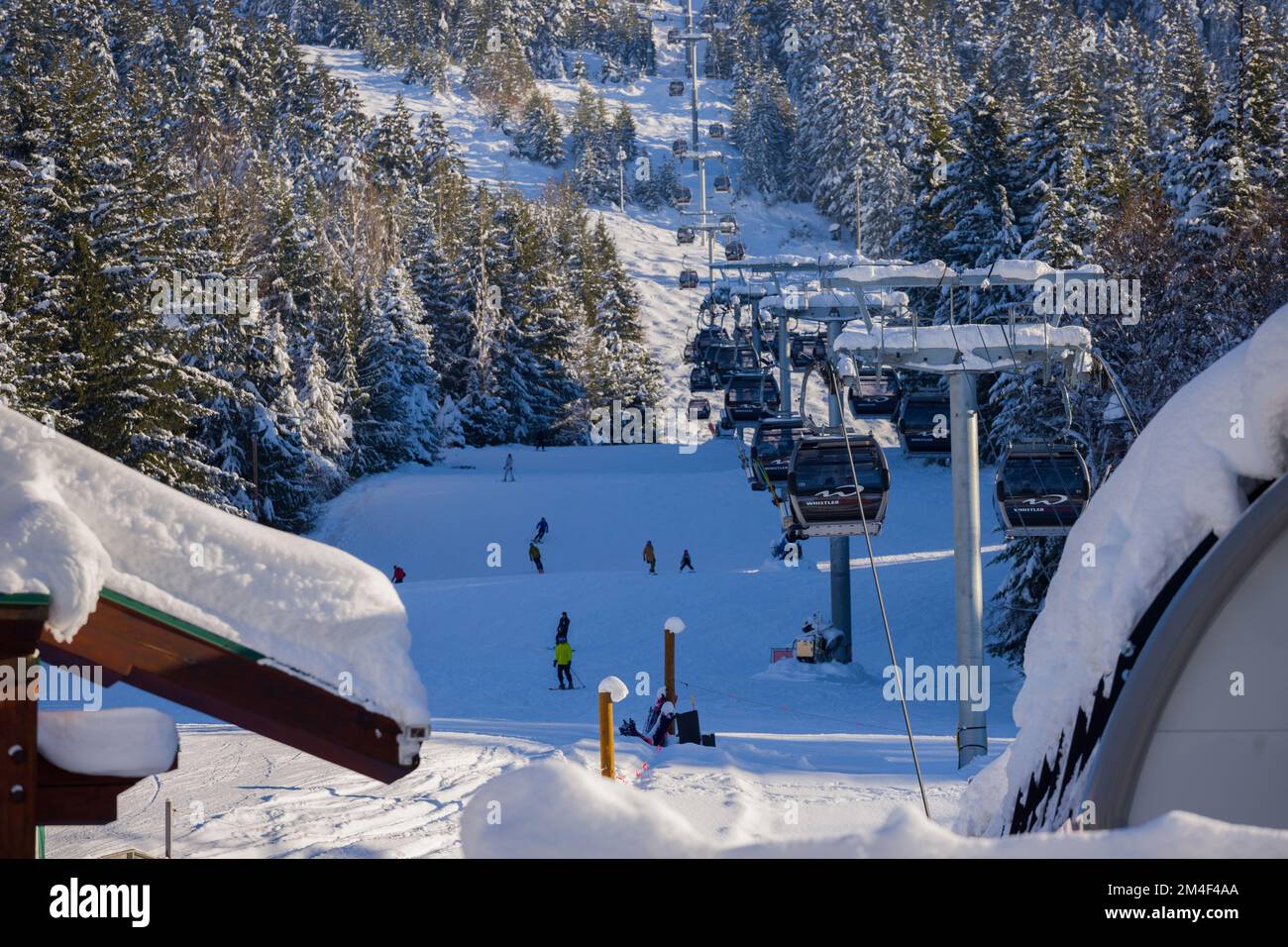 Snow covered mountains panorama - snowboarders and skiers ride on ...