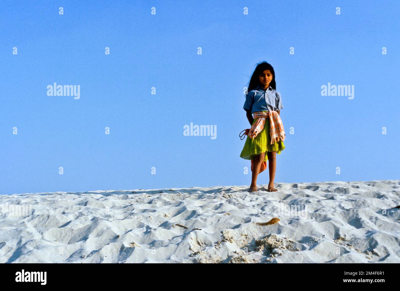 Children playing in the white sand of the banks of the holy river ...