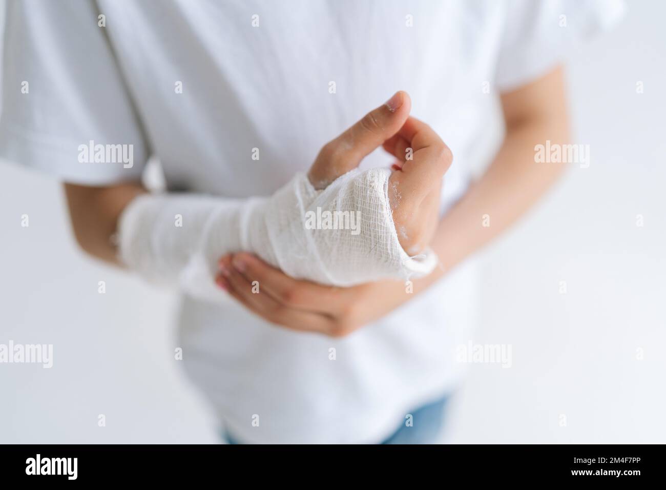 Close-up high-angle view of unrecognizable little girl with broken hand ...