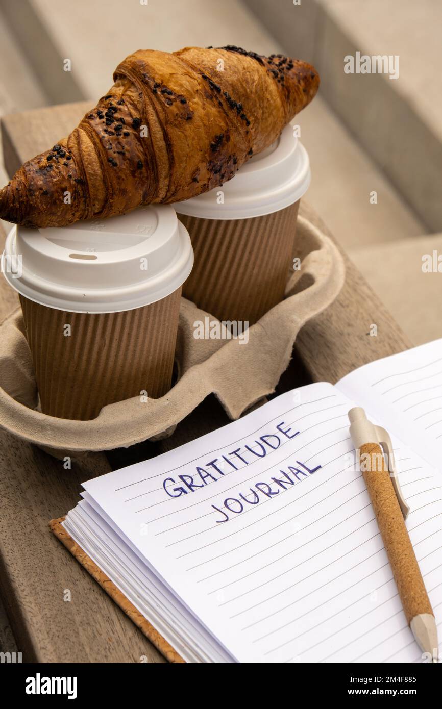 Writing Gratitude Journal on wooden bench. Coffee and croissants ...