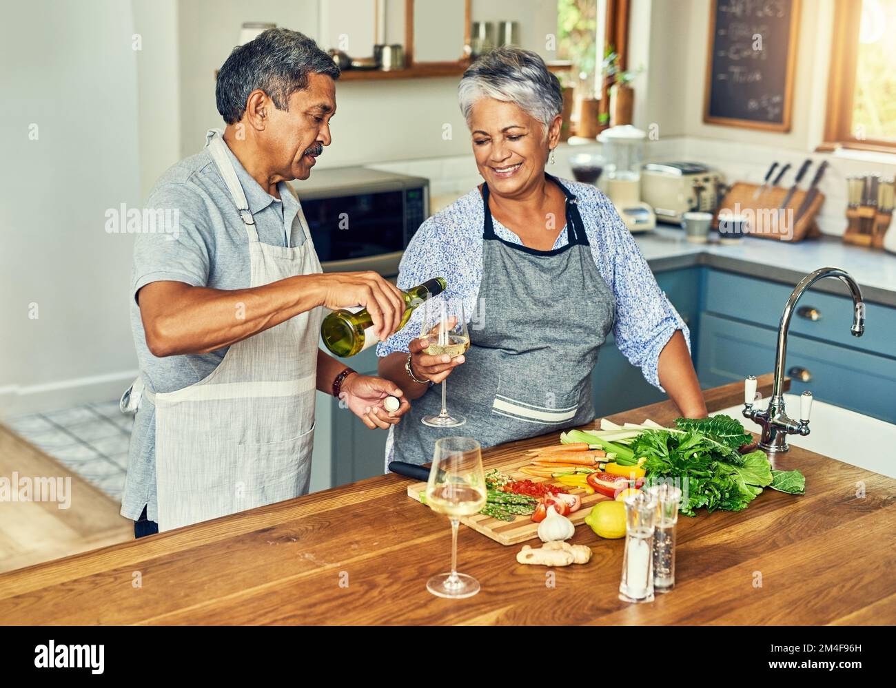 Who said dinner prep has to be a chore. a happy mature couple drinking ...