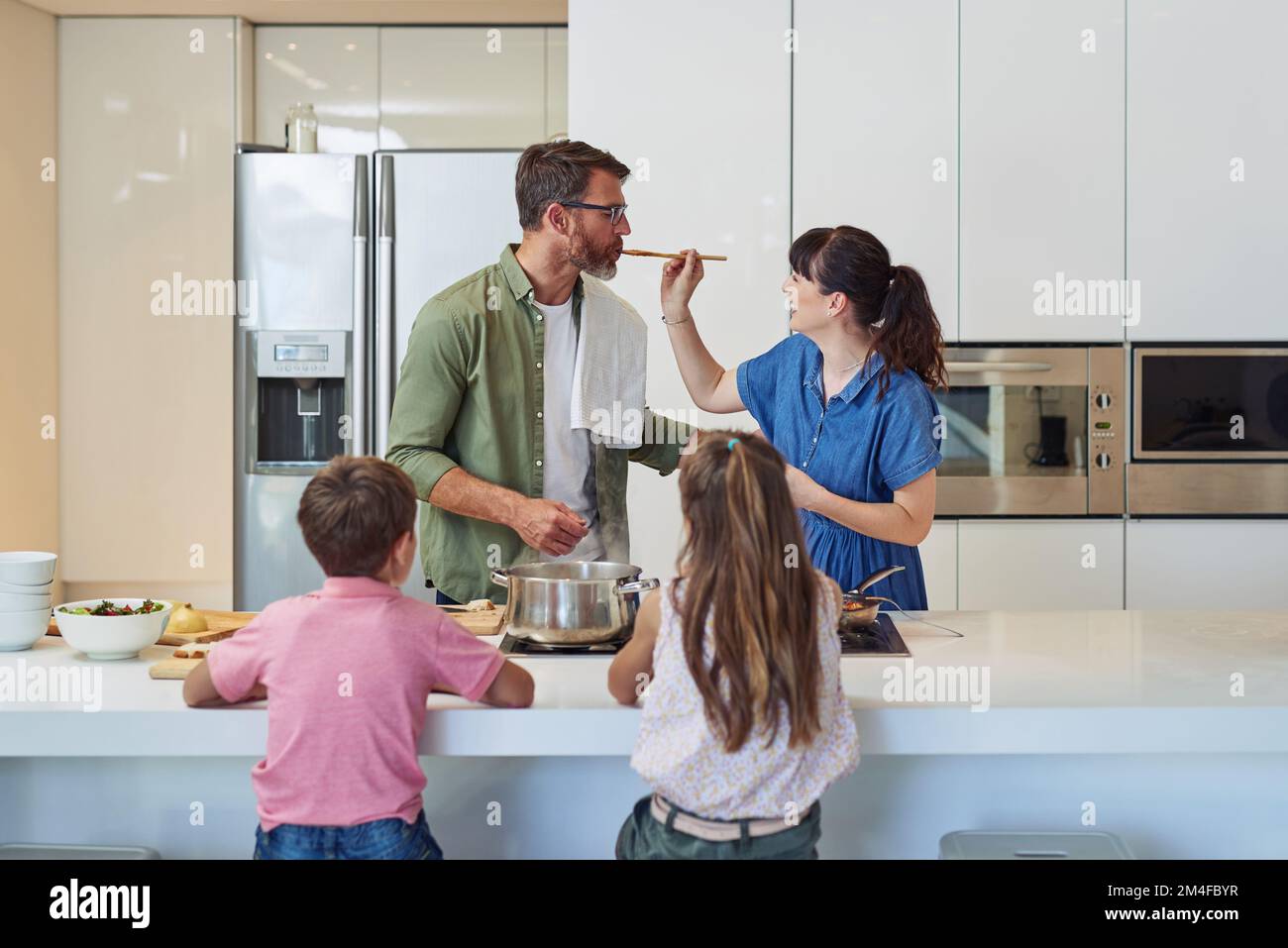 Theyre all eager to dig in to Moms cooking. a mother giving her husband ... Theyre all eager to dig in to Moms cooking. a mother giving her husband ...