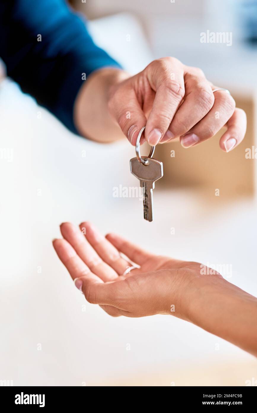 This is for you. a unrecognizable person receiving a key from another ...