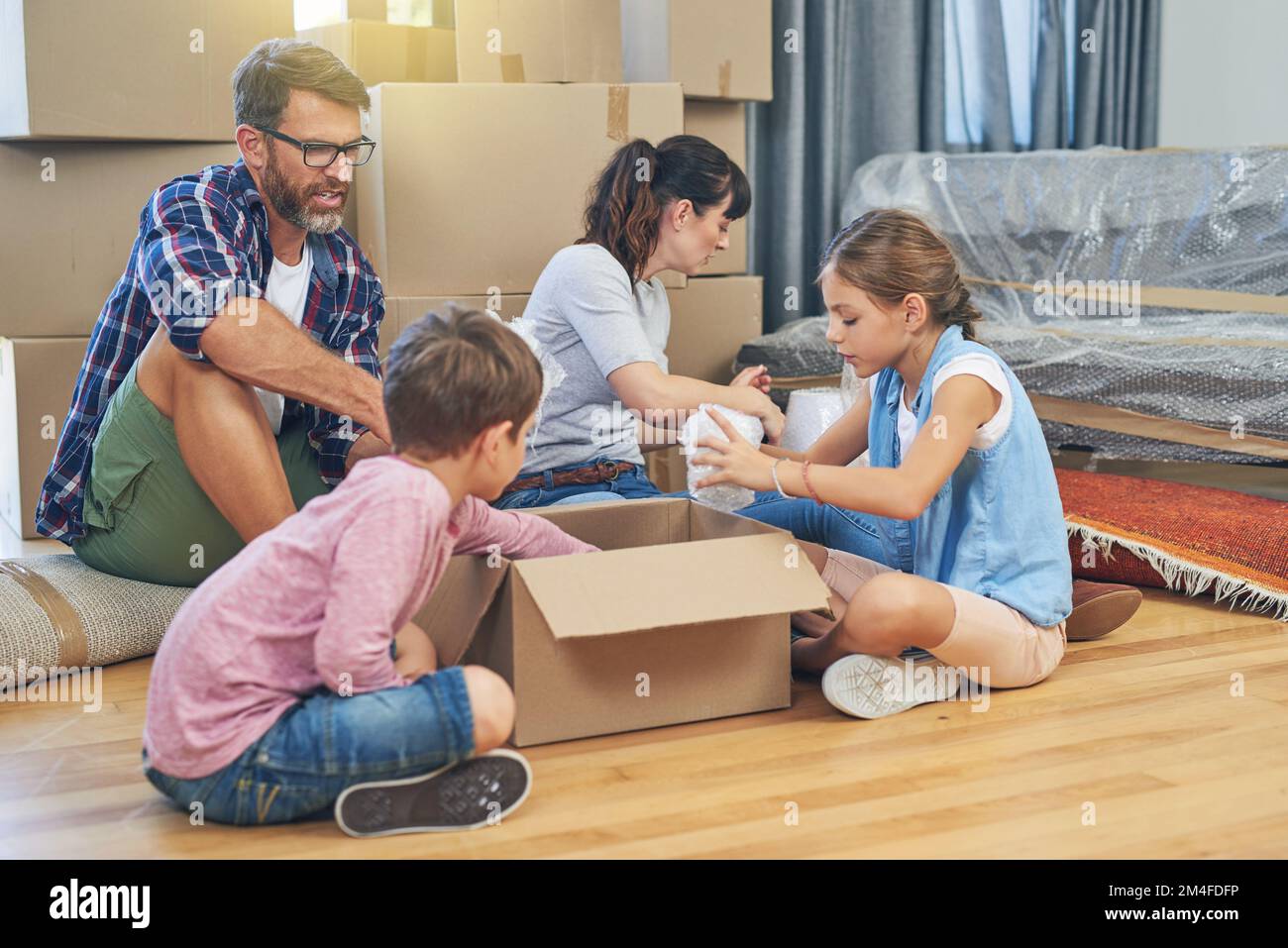Packing as a family, a lesson in teamwork. a family of four helping ...